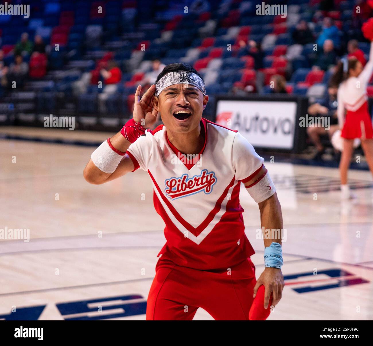 A member of the cheer team for a Liberty Lady Flames signals to the ...