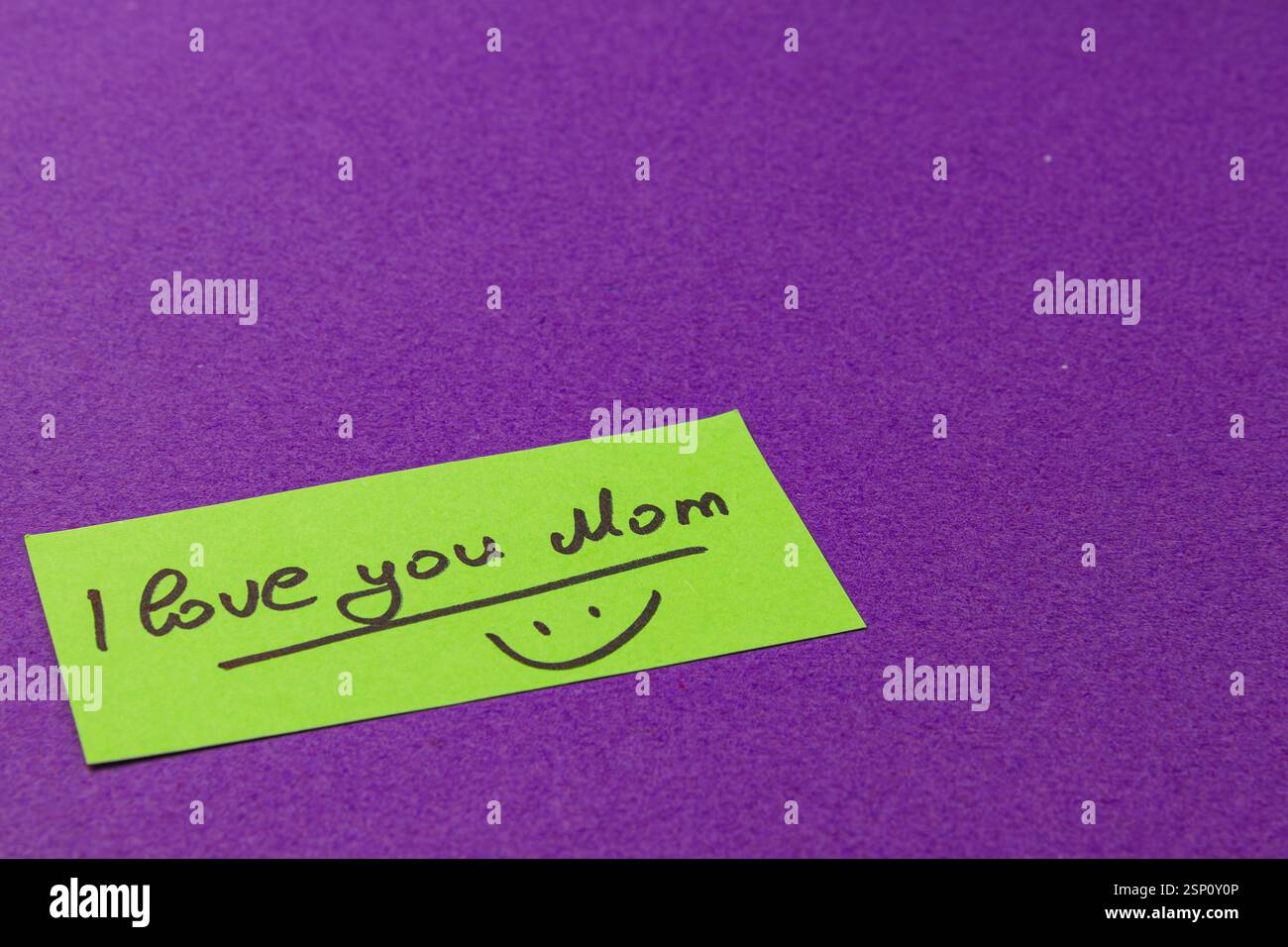 A green sticky note expressing love for mom is placed on a vibrant ...