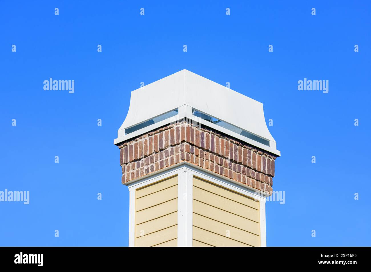 Decorative residential chimney constructed with red bricks and beige ...