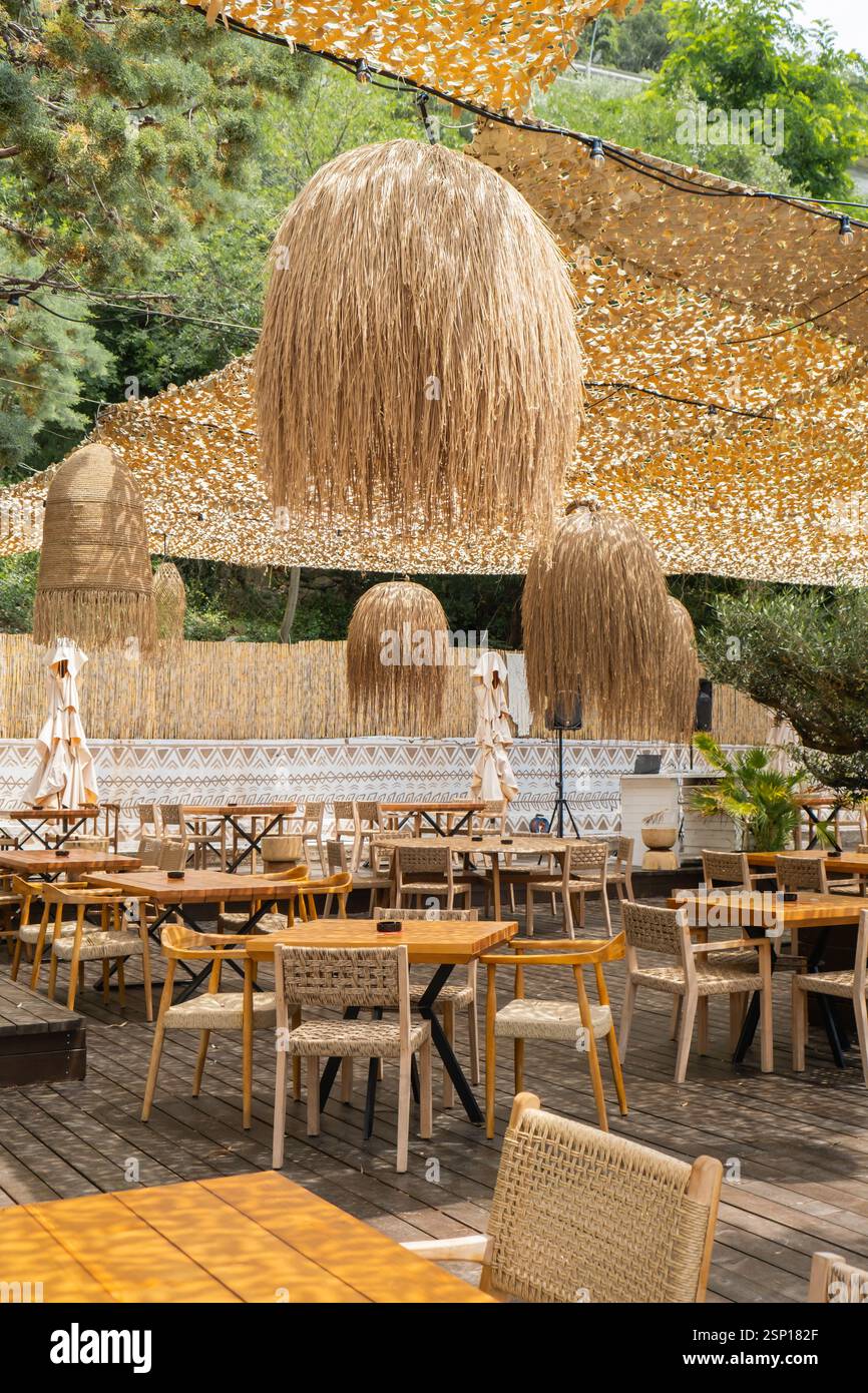 Cozy creative interior of outdoor cafe on beach seacoast. Wooden tables ...