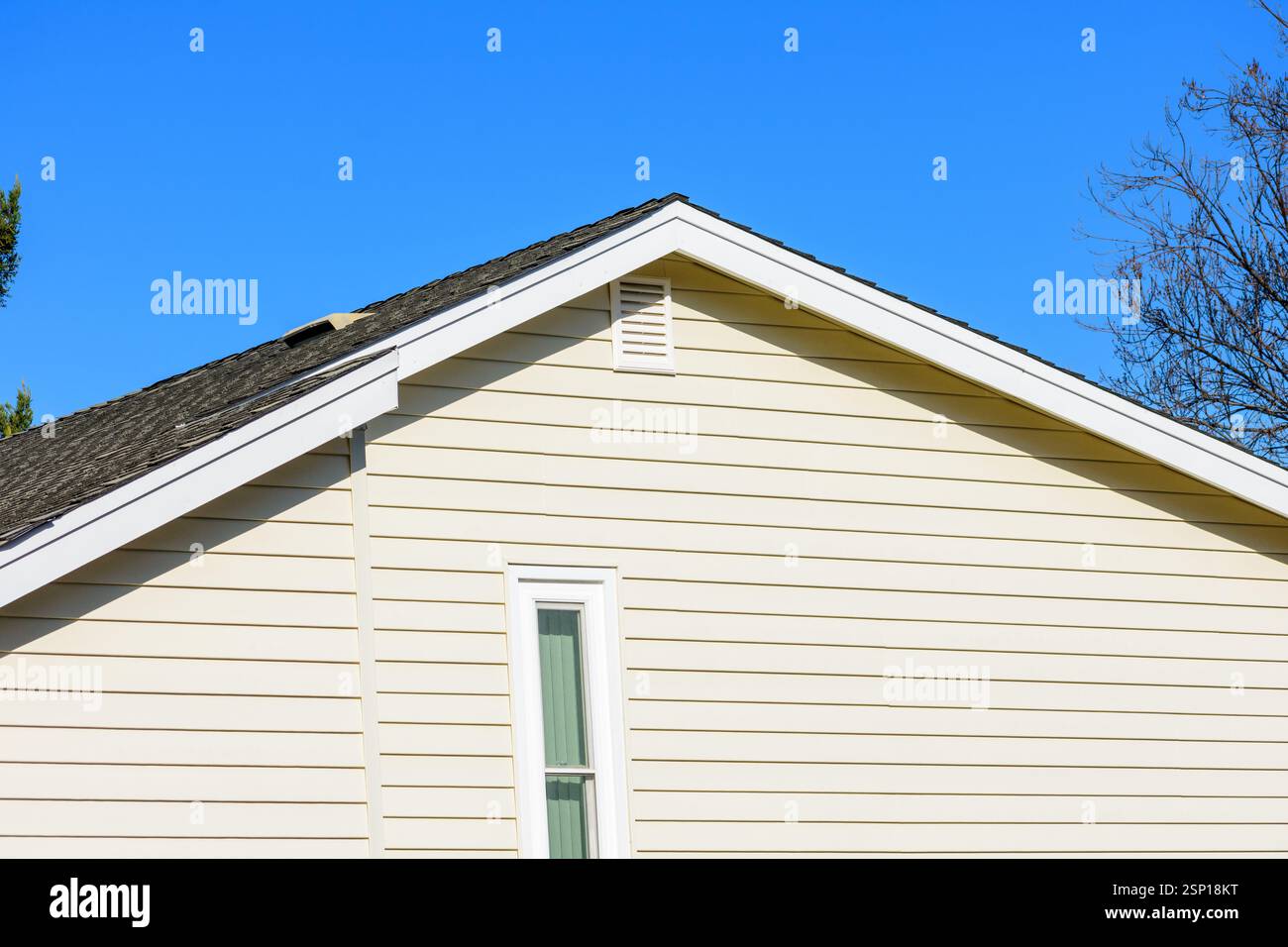 A beige house exterior with horizontal siding, featuring a gable roof ...