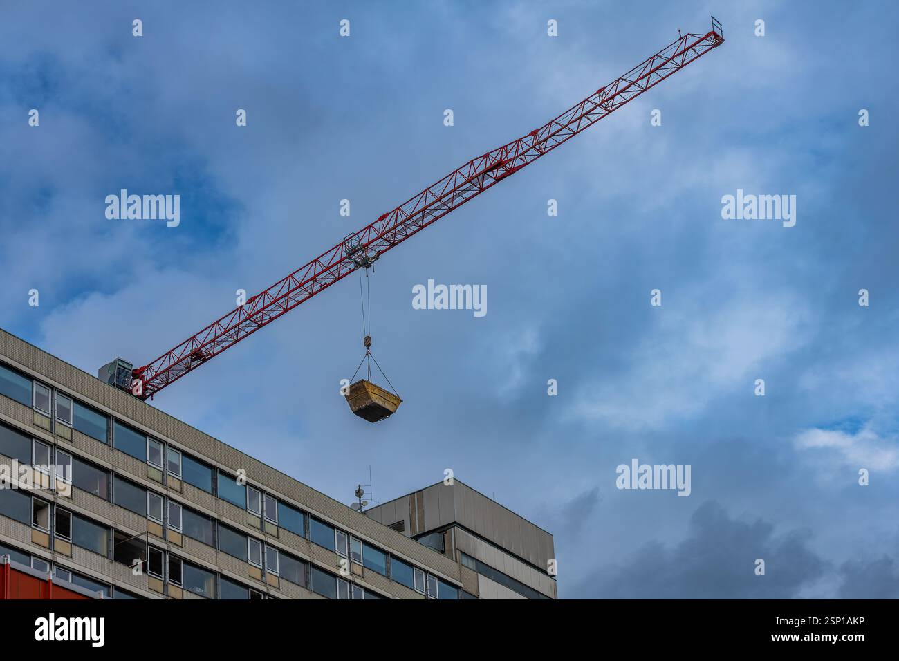 Yellow old skip bin hanging on chains Stock Photo - Alamy