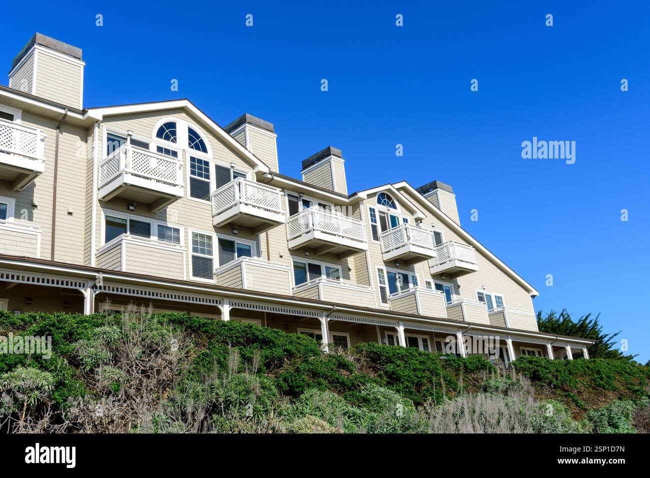 Modern seaside residential apartments building with beige siding, white ...