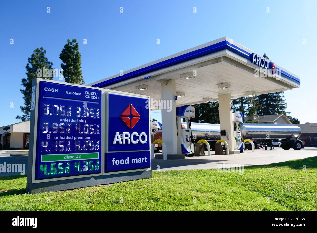 ARCO gas station exterior with fuel price sign, fuel pumps and a tanker truck - California, USA ...