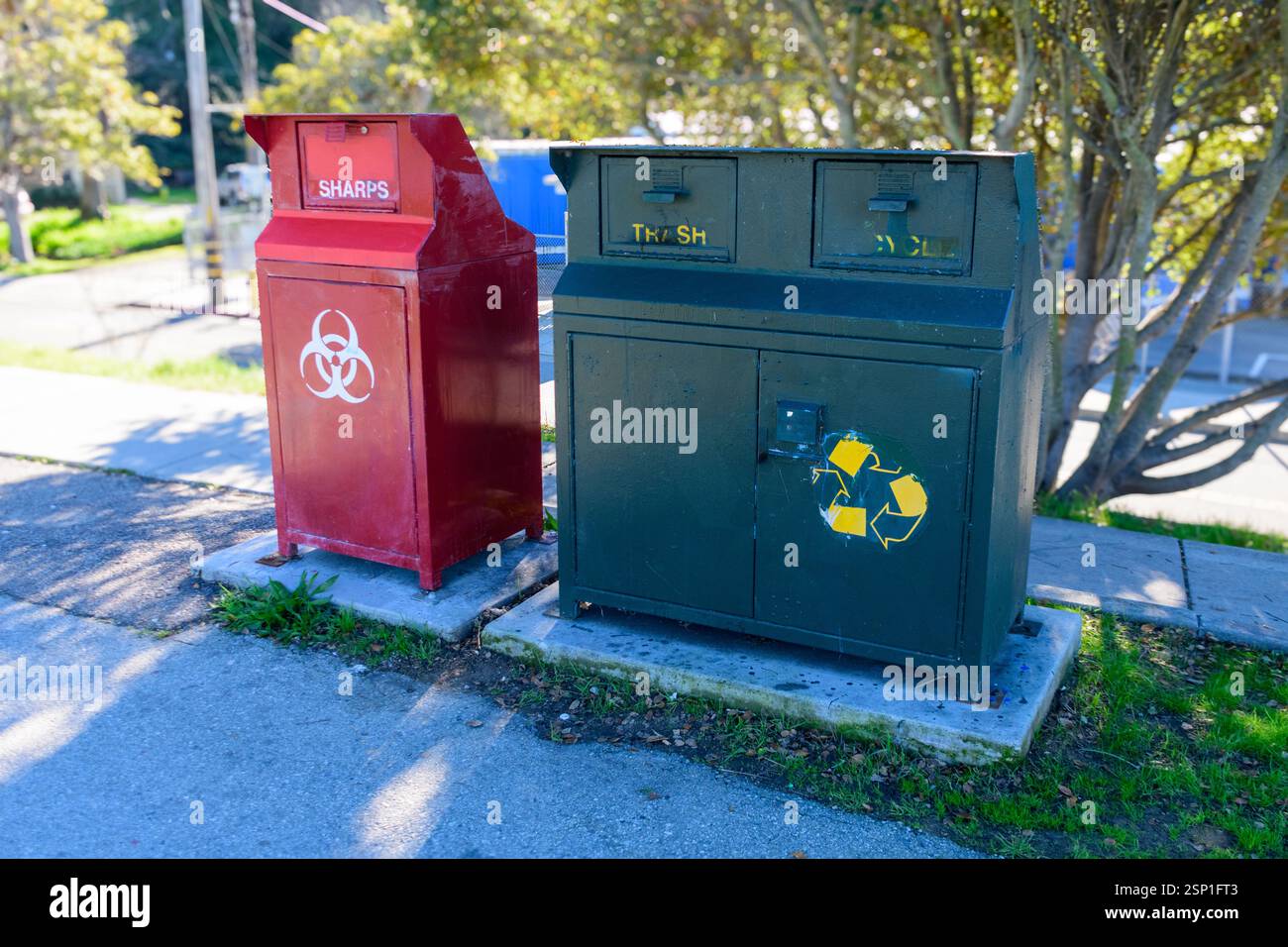 A red biohazard sharps box and a green trash and recycling bin on a ...