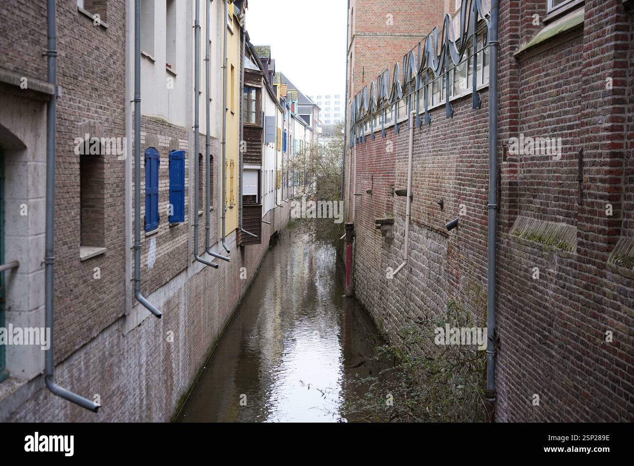 A narrow canal in Amiens, France, surrounded by historic brick ...