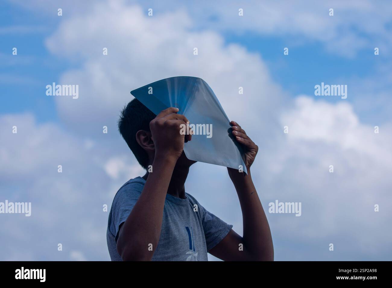 A man observes the solar eclipse through an X-ray plate in Dhaka ...