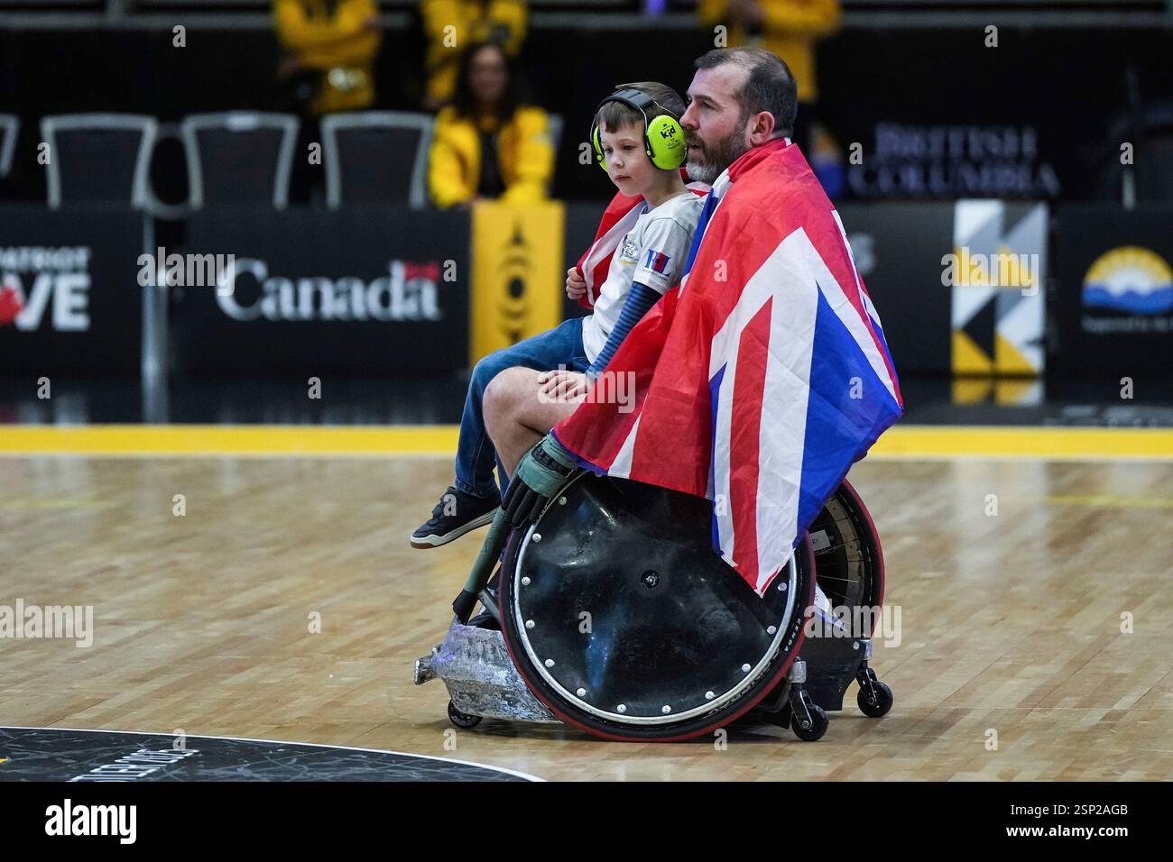 Steven Irwin, of the U.K., sits with his son after France defeated the ...