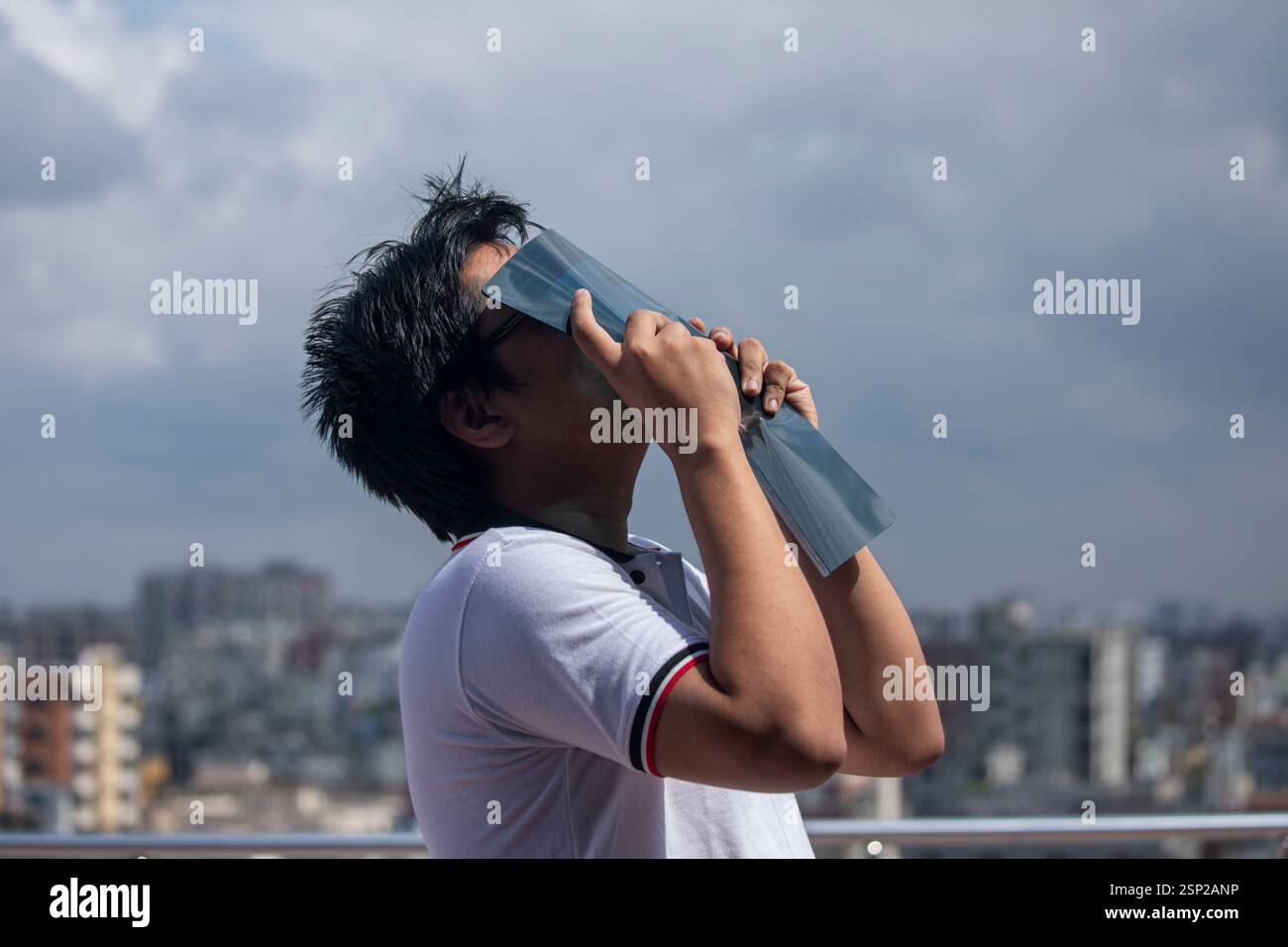 A man observes the solar eclipse through an X-ray plate in Dhaka ...