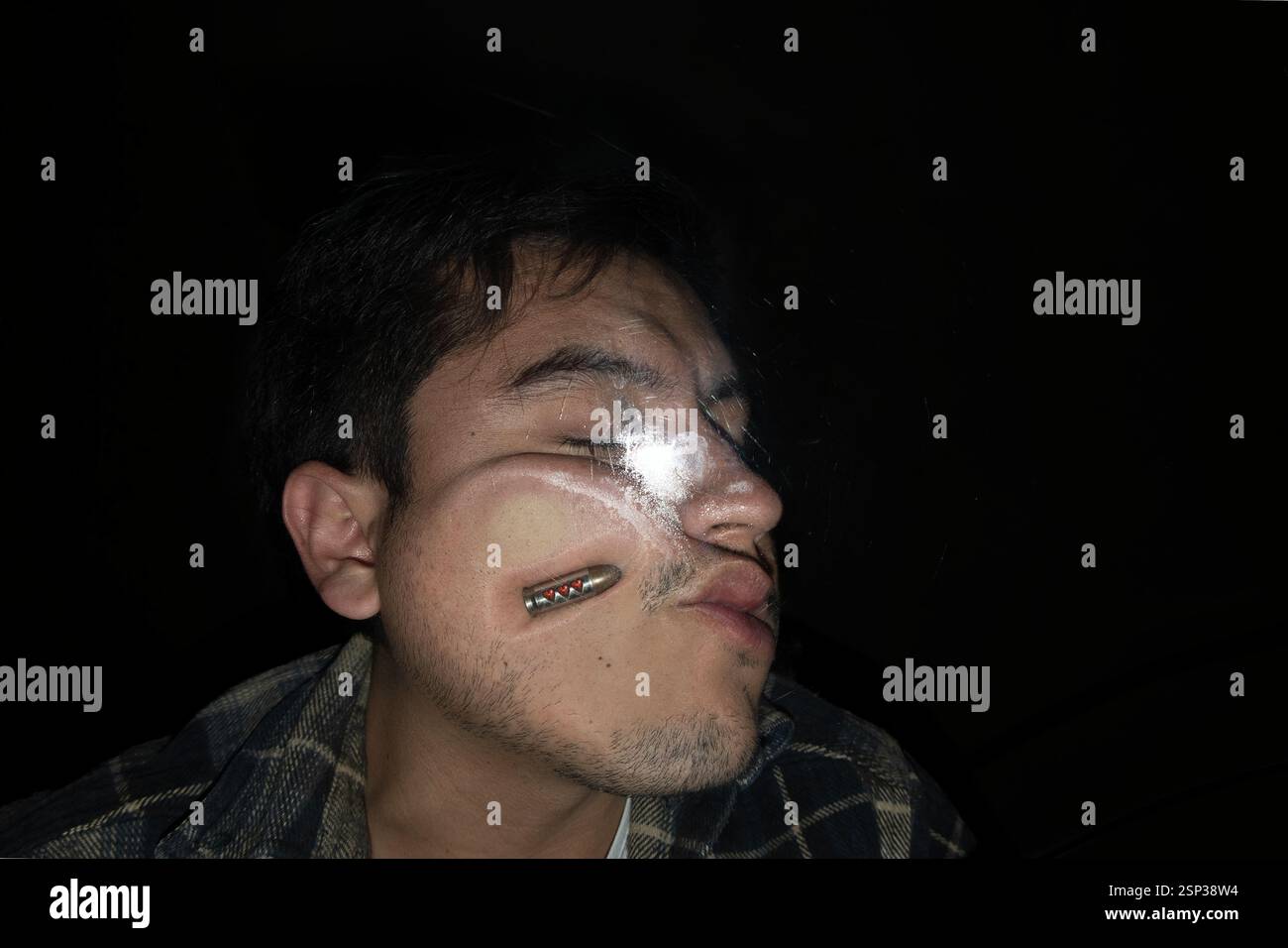 A man is playfully pressing his face against a glass surface, creating ...