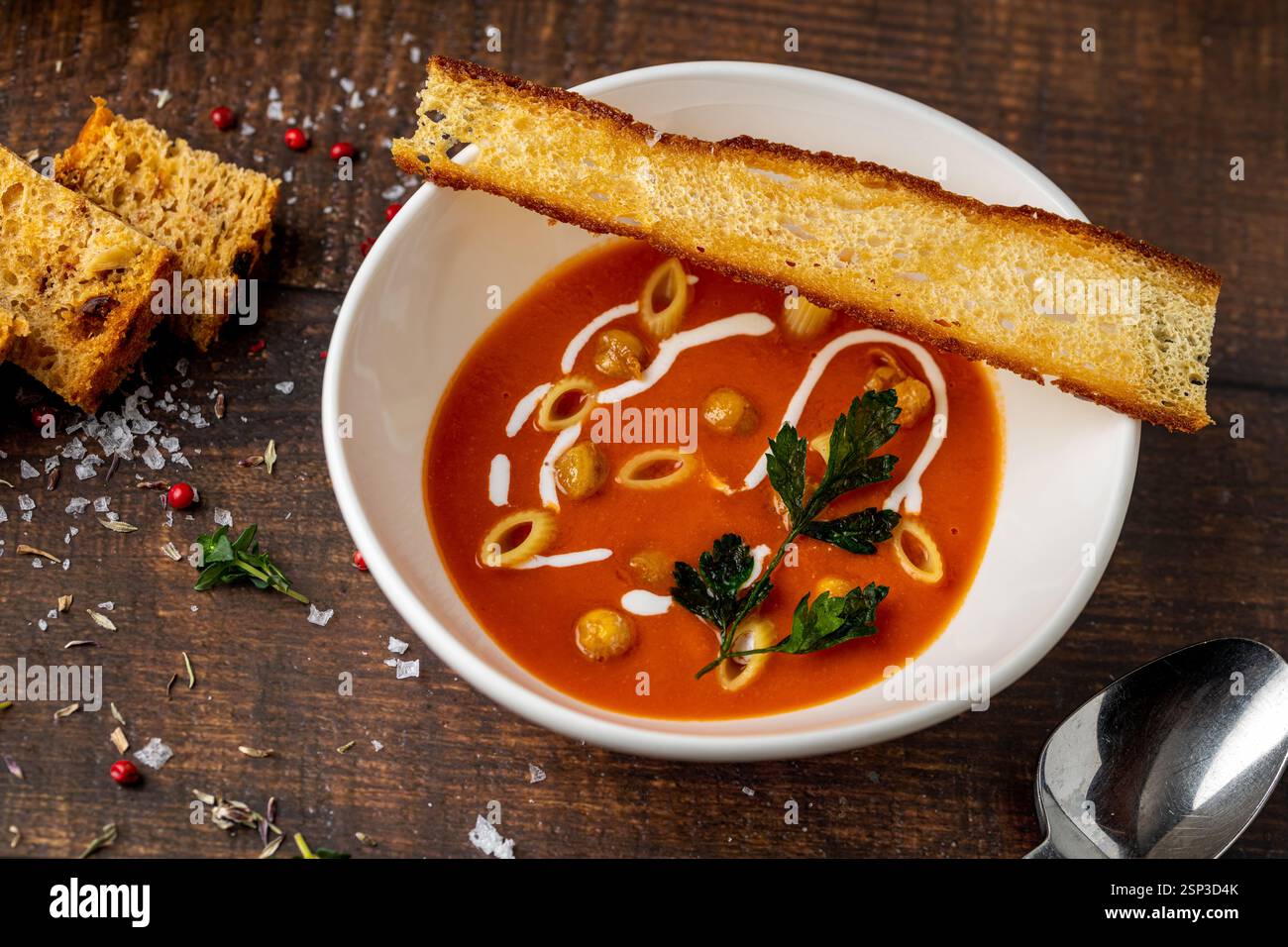 Tomato soup with pasta, roasted chickpeas, cream, and toast on top ...