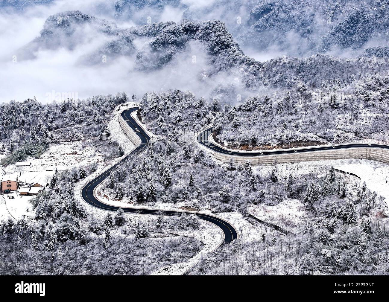 Aerial photo shows the scenery of a winding road after snow in Luojia ...