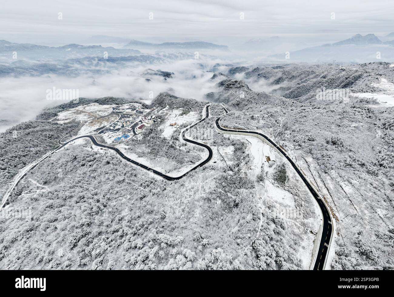 Aerial photo shows the scenery of a winding road after snow in Luojia ...