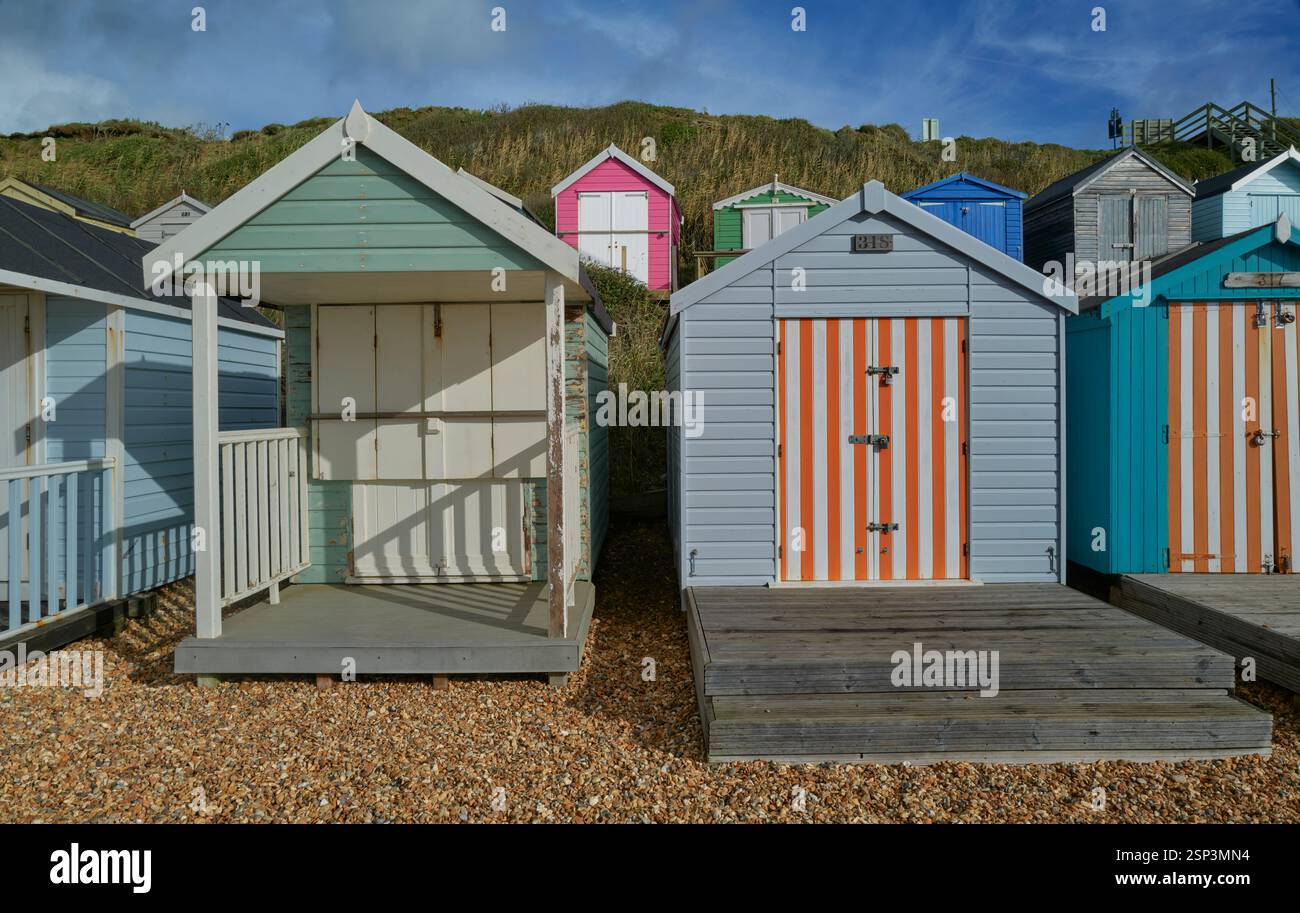 Traditional wooden painted colourful painted beach huts on the shingle ...