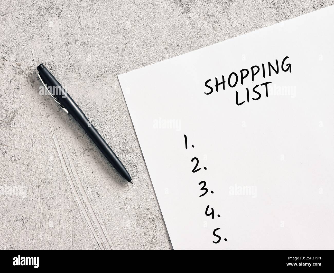 Shopping list with black pen on gray concrete table background ...