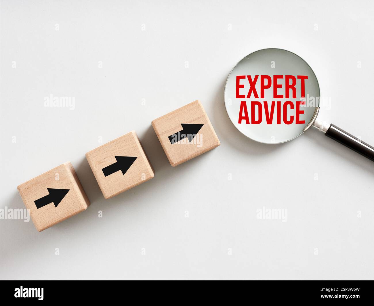 Magnifying glass focusing on expert advice, with wooden cubes and ...