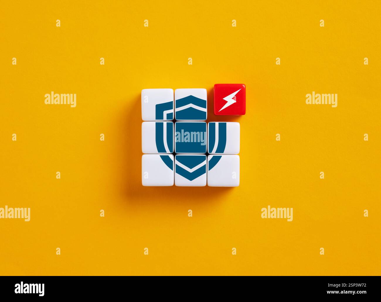Toy cubes forming a shield symbol being attacked by a lightning bolt cube placed on a yellow ...