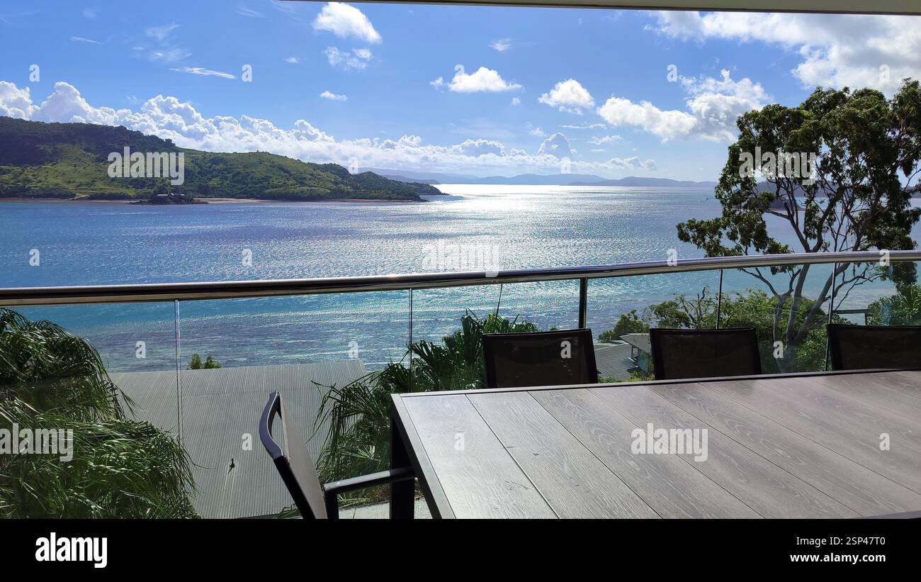 The photo shows a table and two chairs on a balcony overlooking the ...