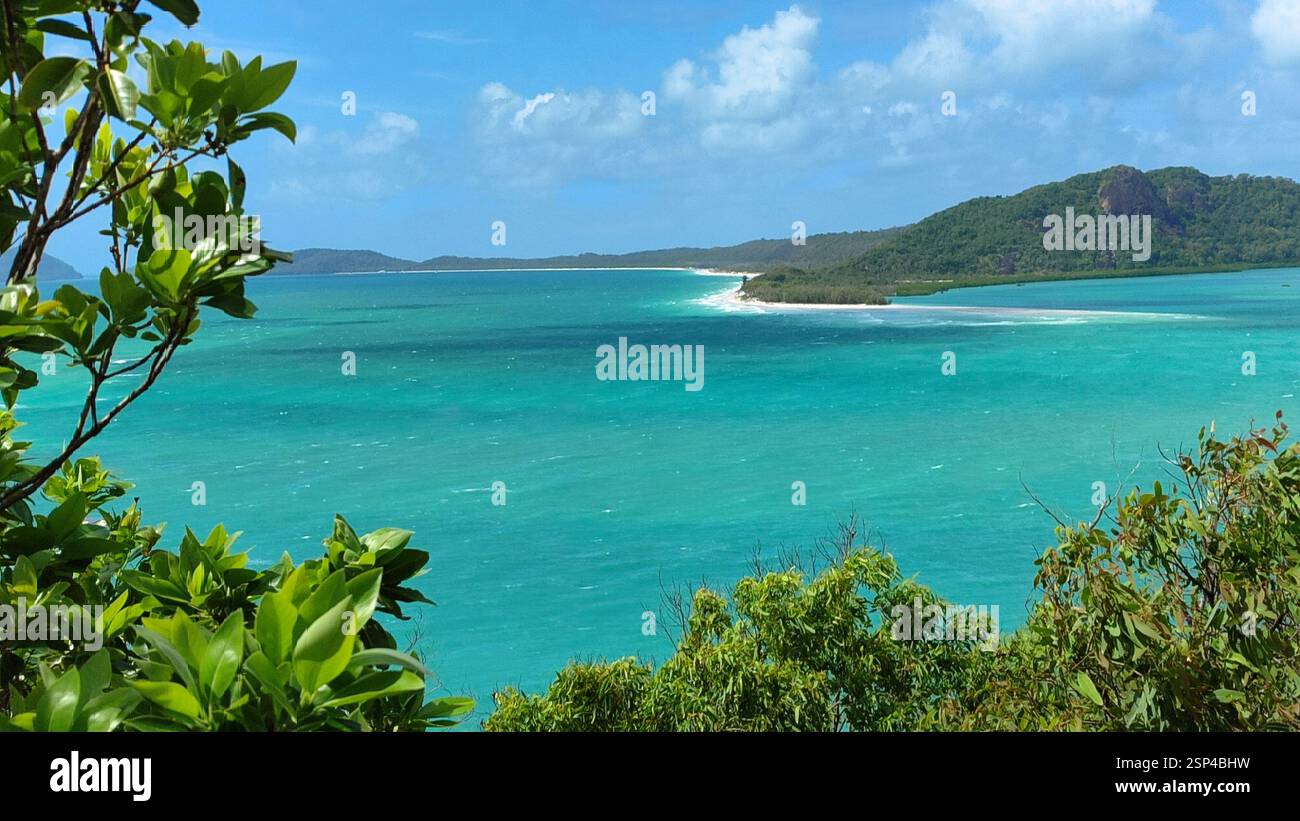 A tropical island features a white sandy beach surrounded by turquoise ...
