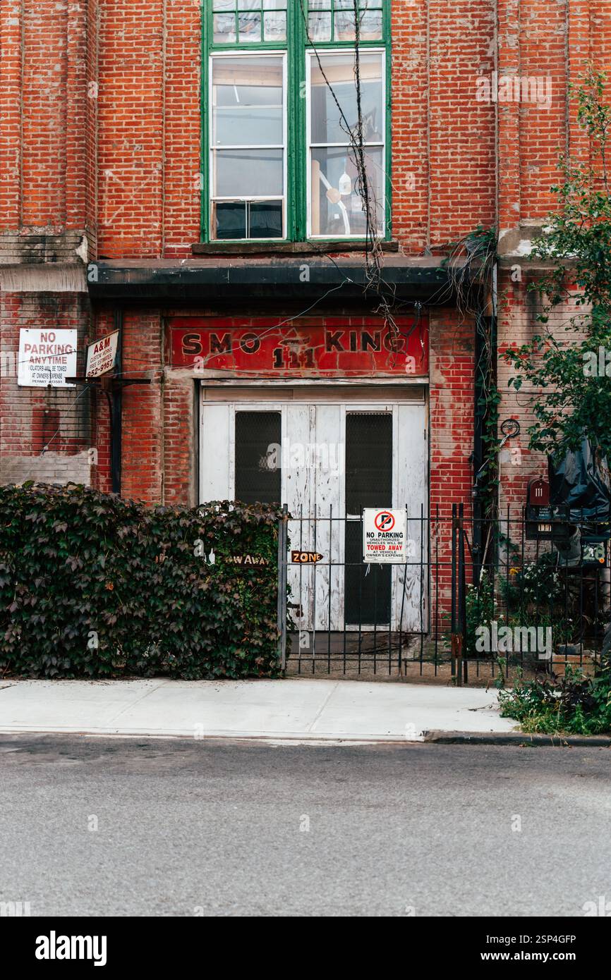 A classic brick building stands in a bustling New York neighborhood ...