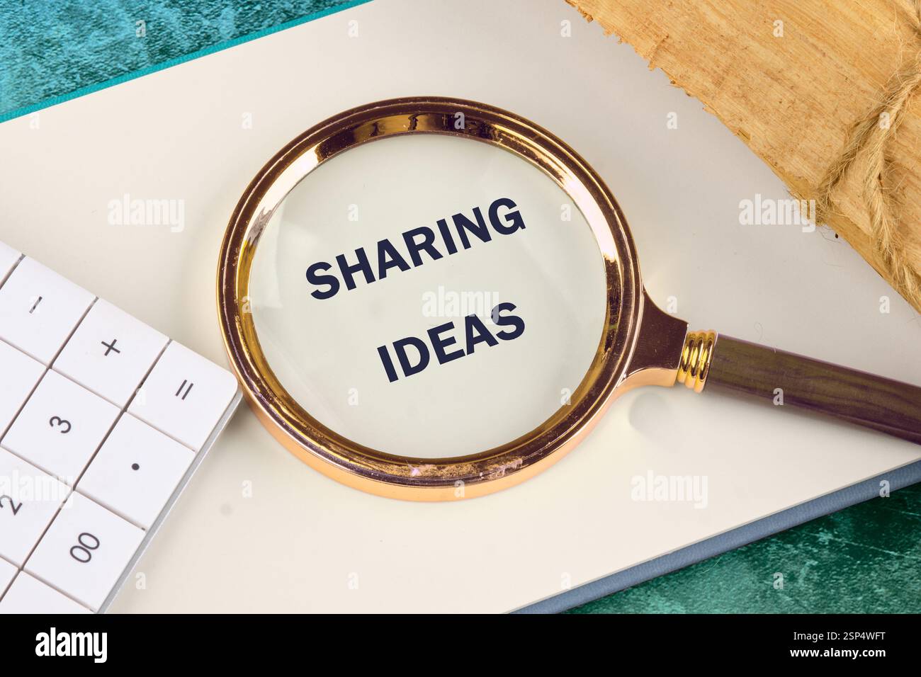 A magnifying glass highlights the text 'sharing ideas' on a notepad ...