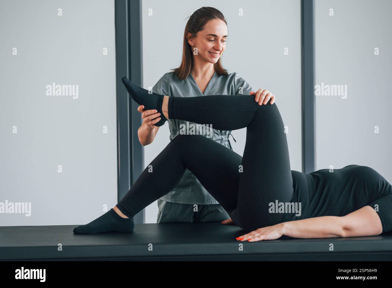 Active exercises. Woman is in health center getting help by doctor ...
