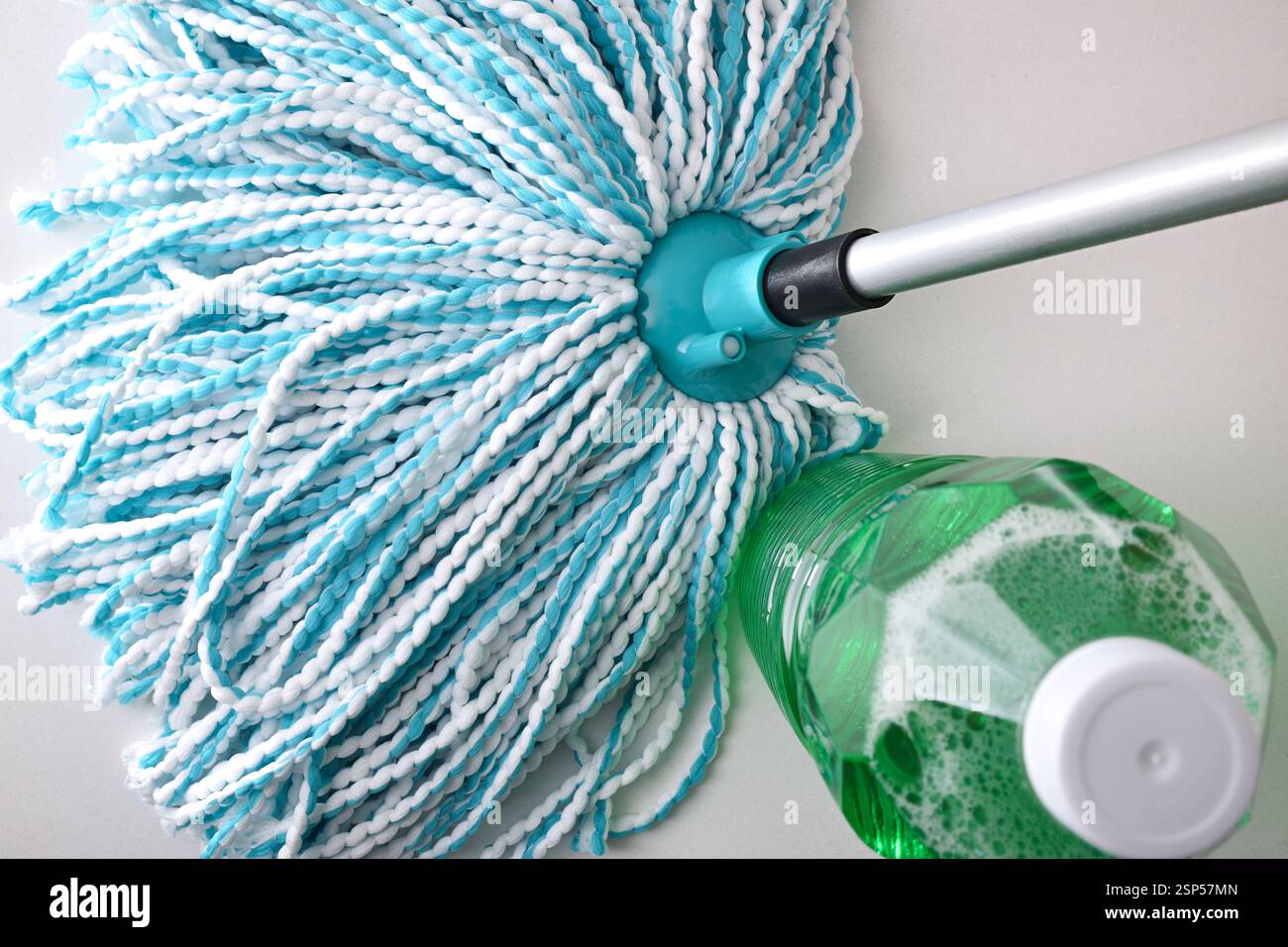 Detail of bottle with green disinfectant product for floors and mop ...