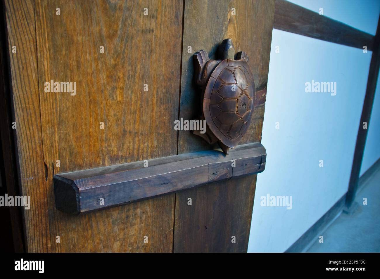 Wooden door with intricately carved turtle knocker. Turtle symbolizes ...
