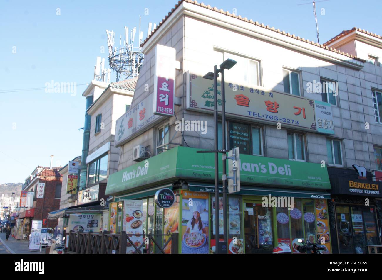 Korean street scene. Multiple storefronts with Korean signage. A ...