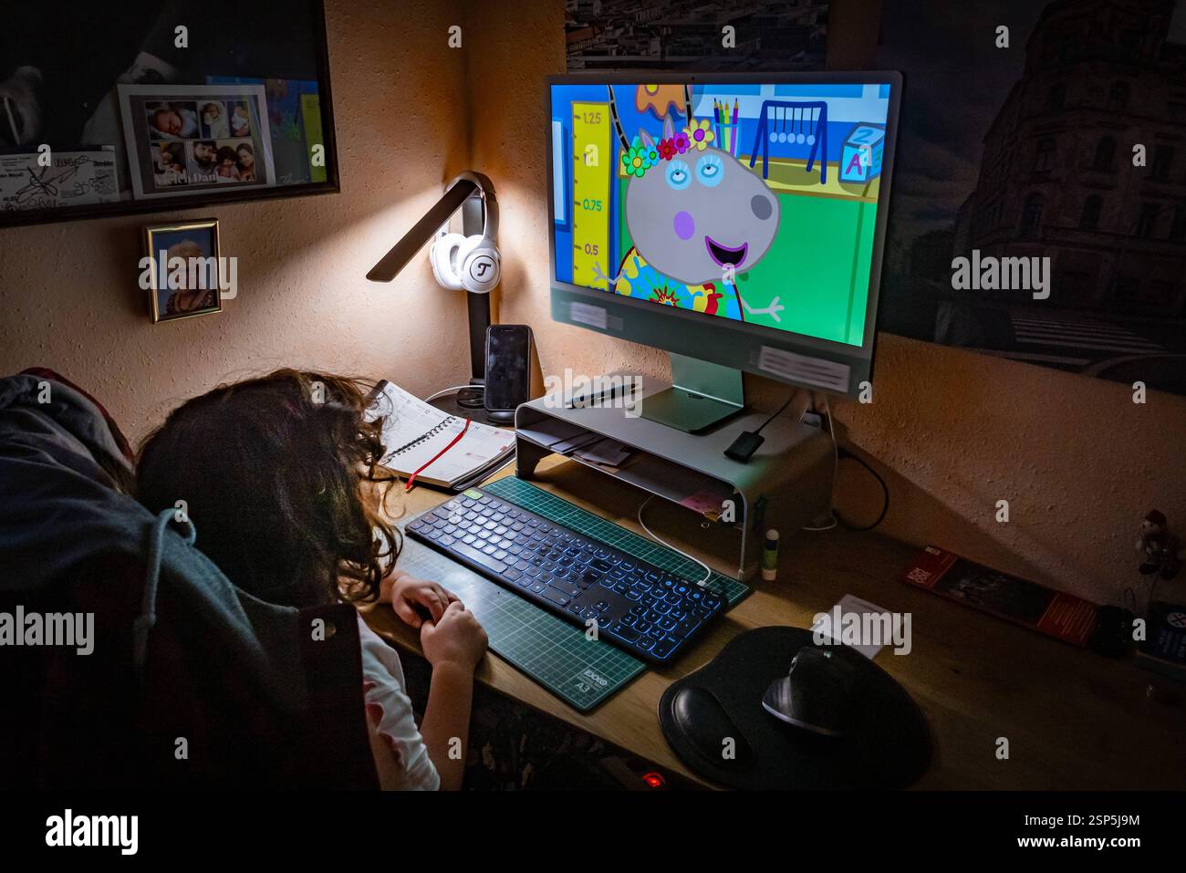 Elena sitzt am iMac / Computer und sieht auf YouTube Peppa Pig - 13.02.2025 Elena Stock Photo ...