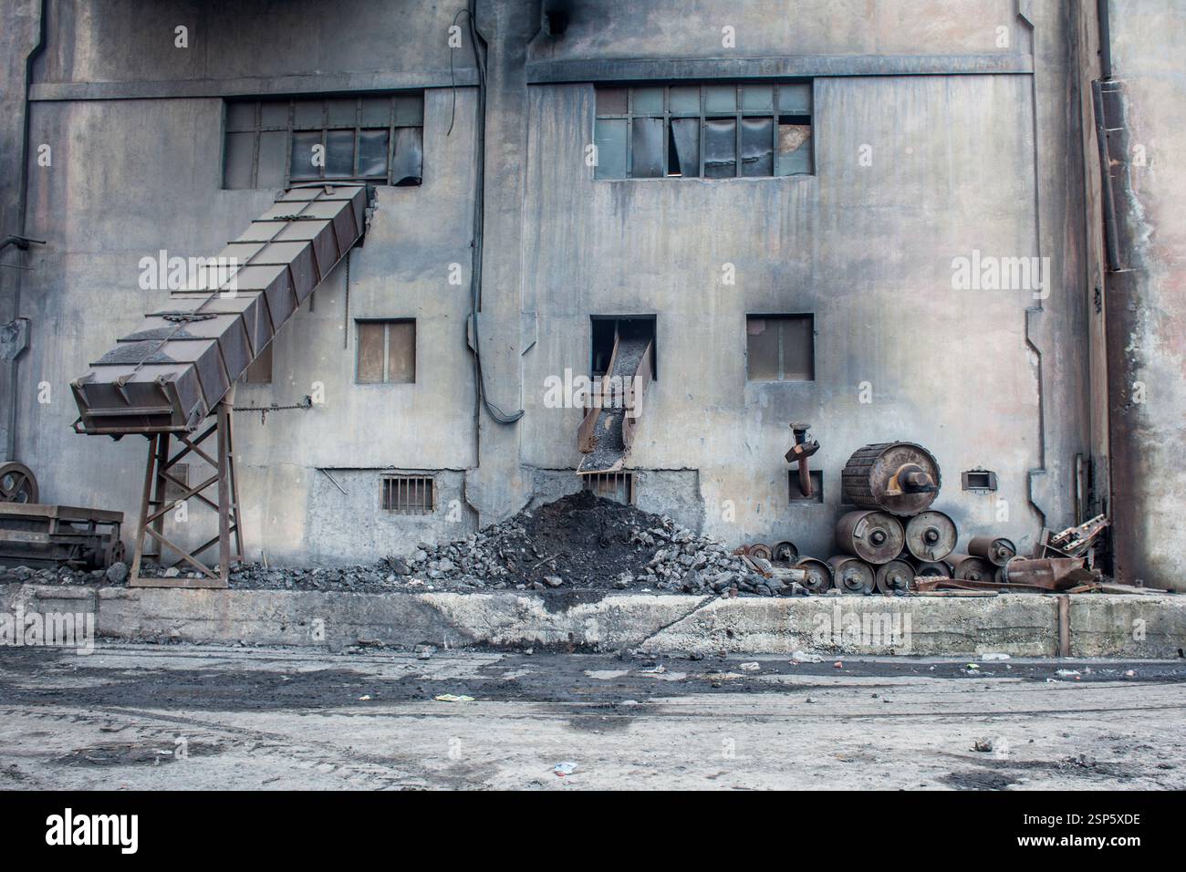 Old industrial building facade with weathered concrete walls, featuring ...