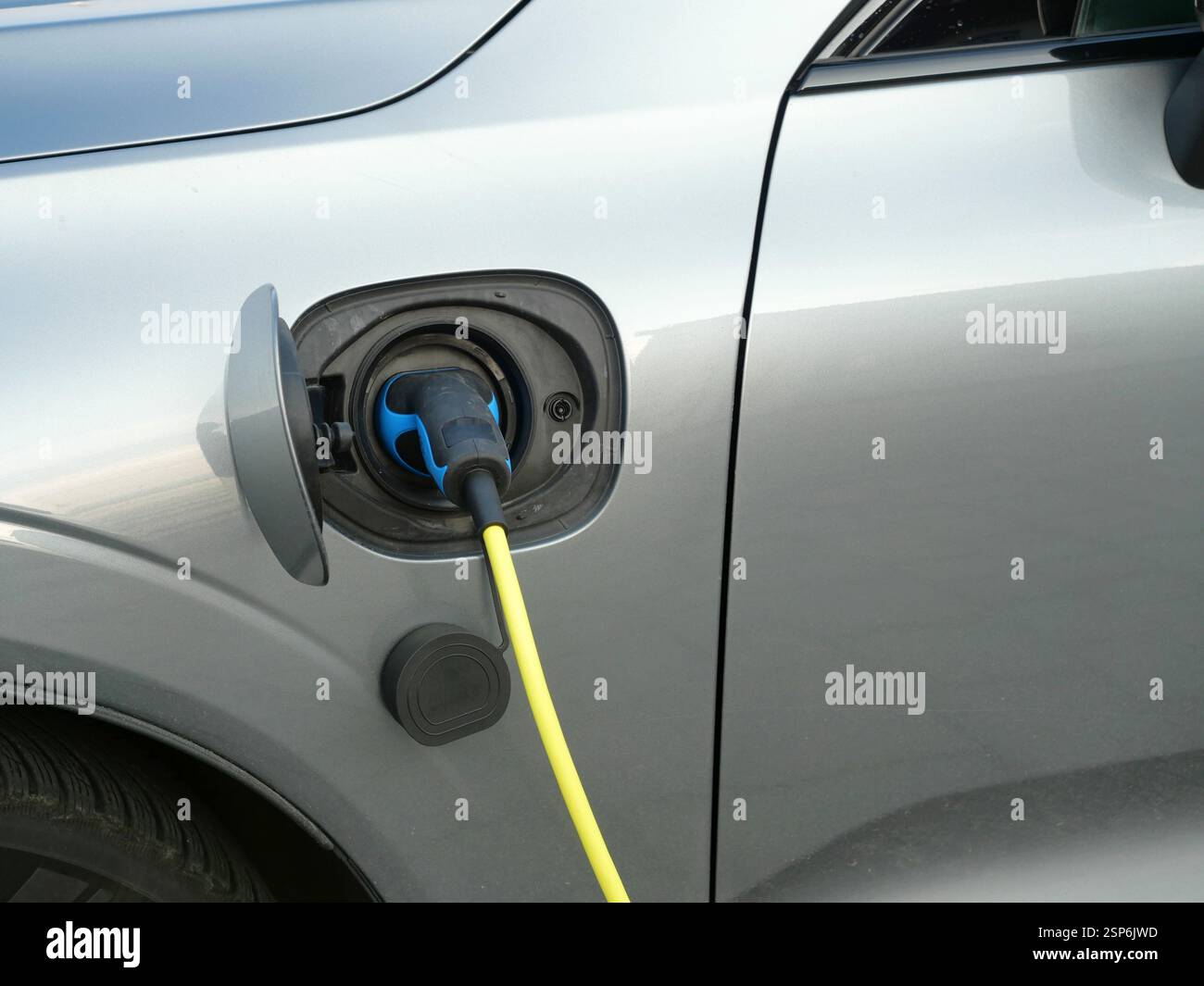 Electric car charging with a cable. A symbol of sustainable mobility ...