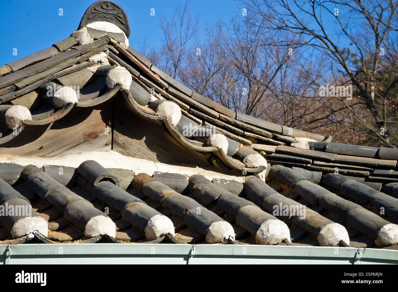 Korean traditional roof tiles. Curved grey tiles with white circles ...