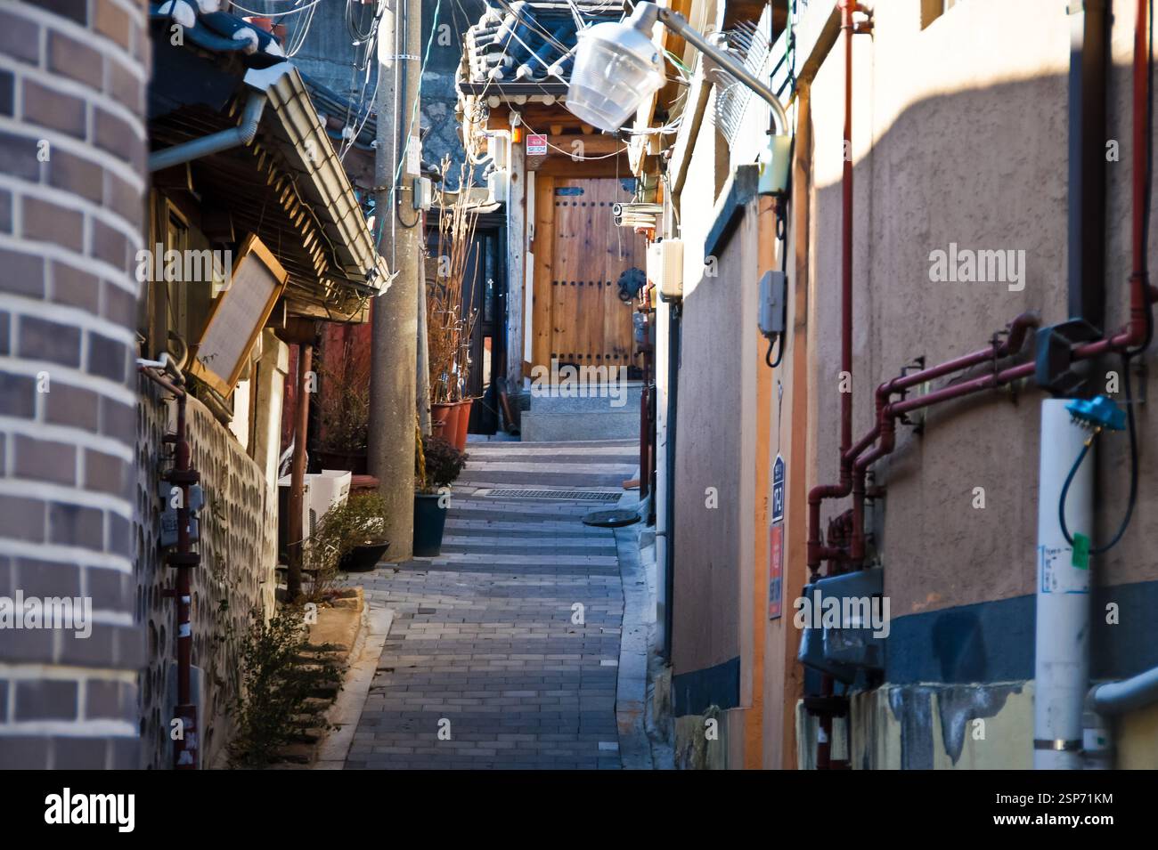 Alleyway. Traditional Korean Hanok houses line a narrow street. Stone ...
