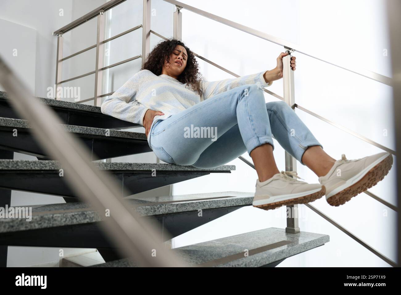 Injured woman on stairs in building after fall. Dangerous accident ...