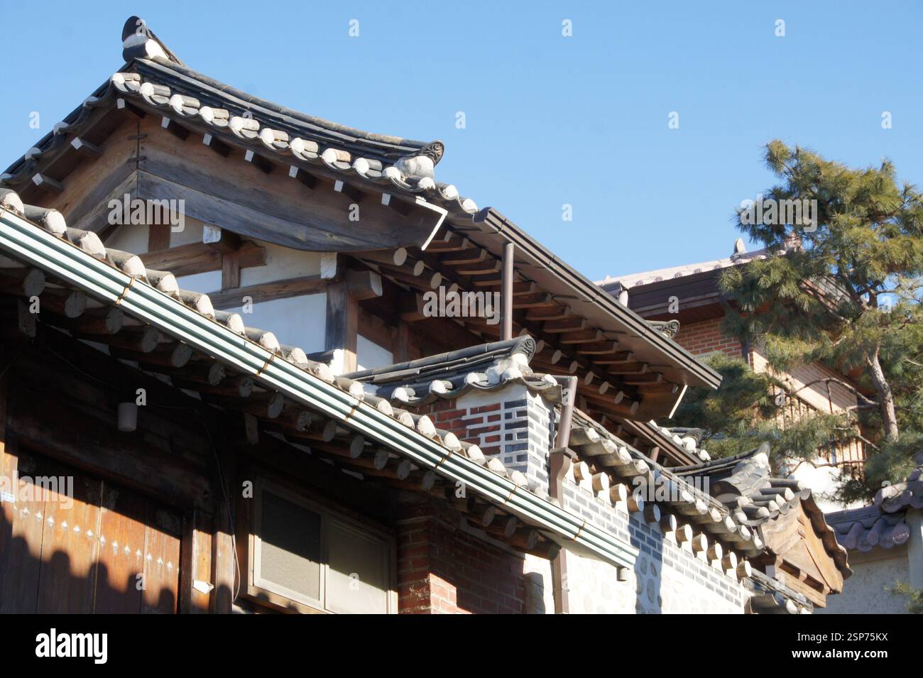 Korean traditional house with tiled roof and curved eaves. Whitewashed ...