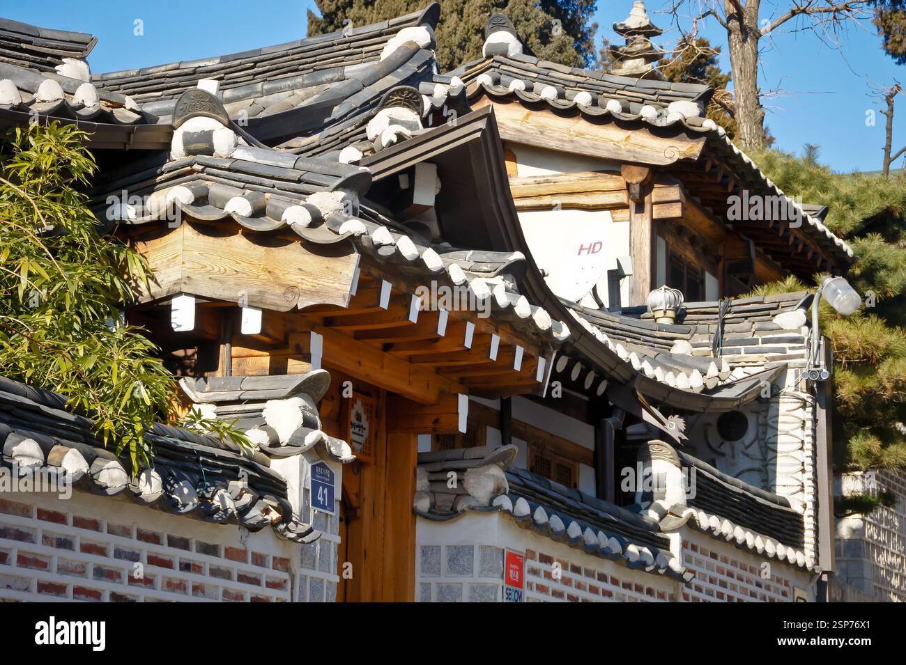 Korean traditional house with tiled roof, curved eaves, and white walls. South Korea's ...