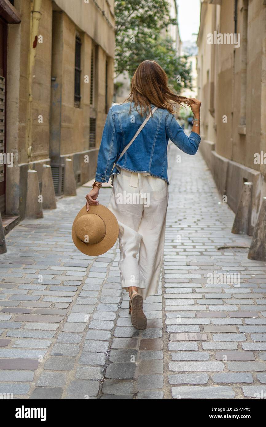 back view of a woman walking on a parisian street Stock Photo - Alamy