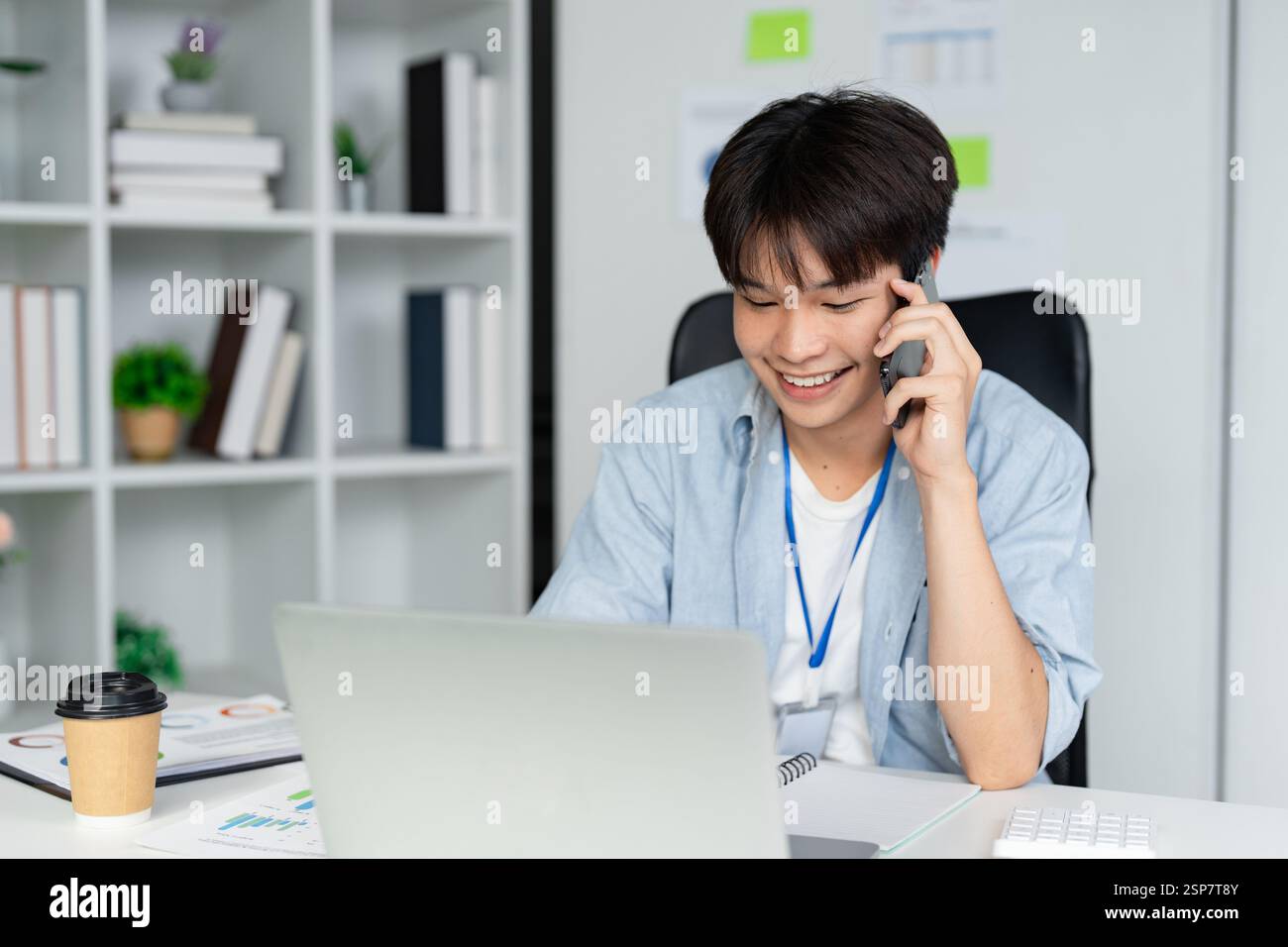 Happy young professional enjoying a phone conversation in a modern ...