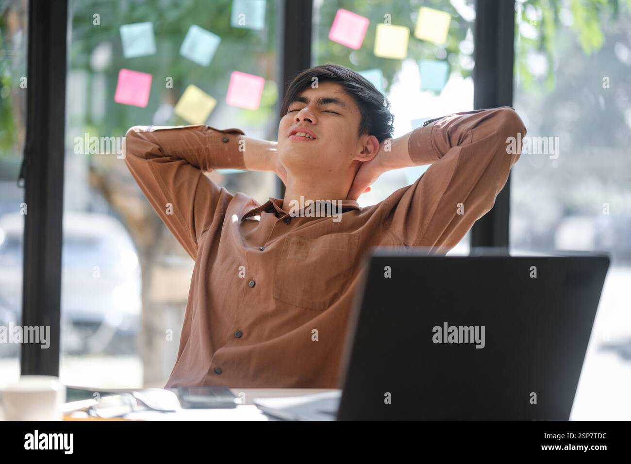 Young man stretching and leaning back to relax after long hours o Stock ...