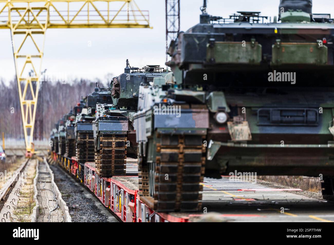 A convoy of German Leopard 2 main battle tanks loaded onto flatbed ...