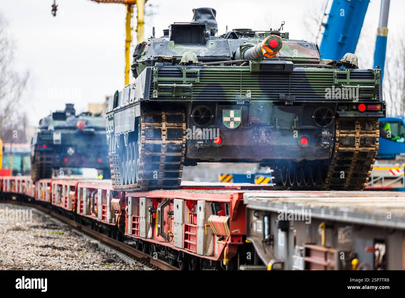 A convoy of German Leopard 2 main battle tanks loaded onto flatbed ...