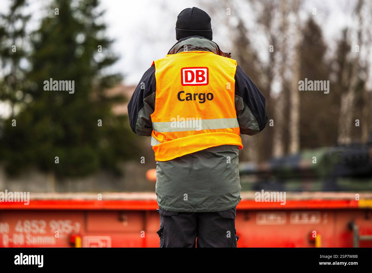 A DB Cargo worker in a high-visibility vest oversees the transport of a ...