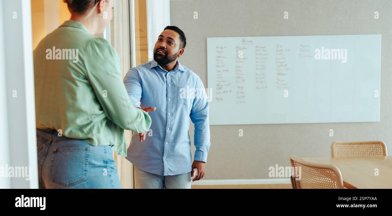 A welcoming handshake between two colleagues. A man in a blue shirt ...