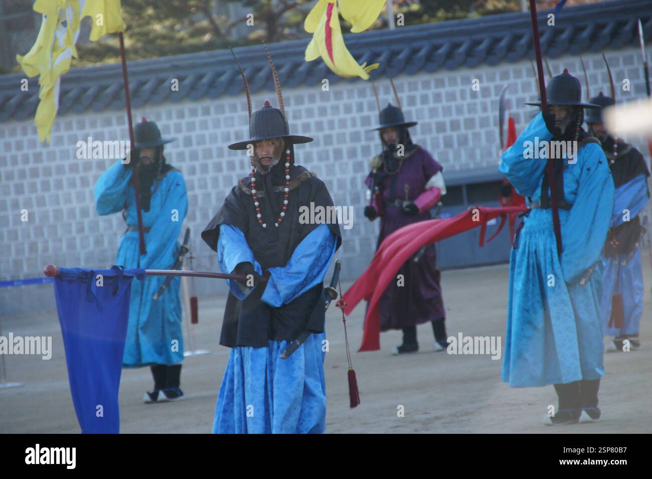 Korean guards in colorful uniforms and hats perform a ceremony. They ...