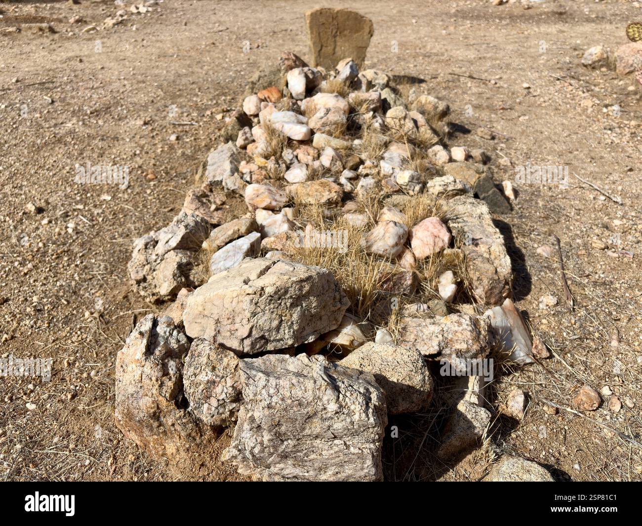 Close-up of a rustic desert grave marked by piled stones and dirt Stock ...