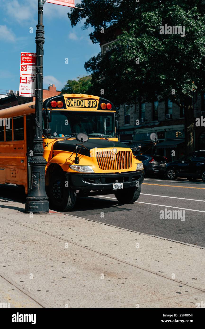Bright yellow school bus parked on a busy New York City street i Stock ...