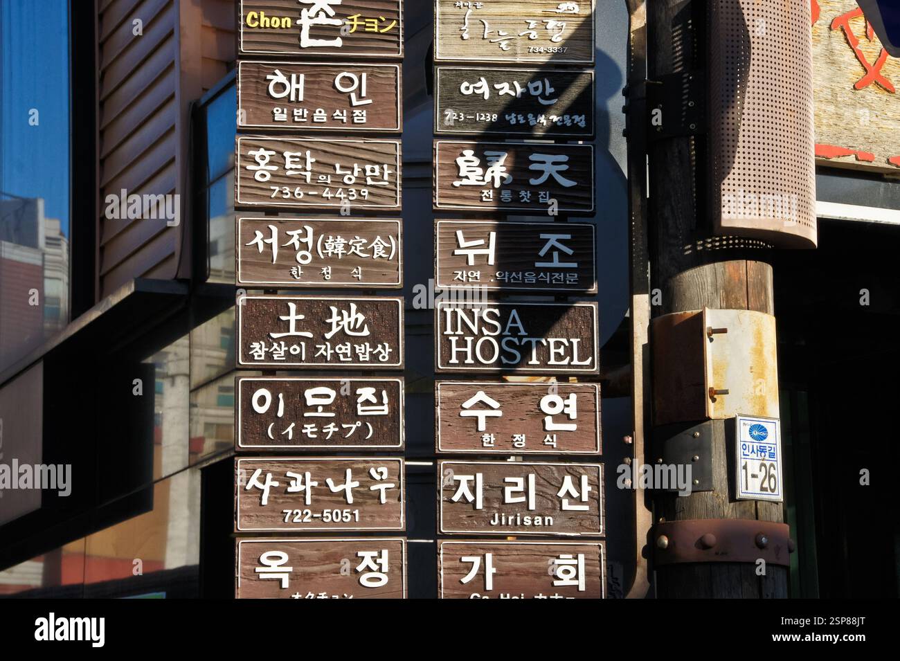 Korean signpost with various business names. Korean characters and some ...
