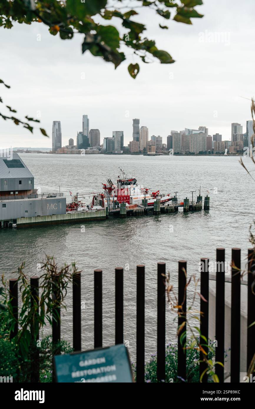 View of a New York City waterfront with a docked boat in early a Stock ...