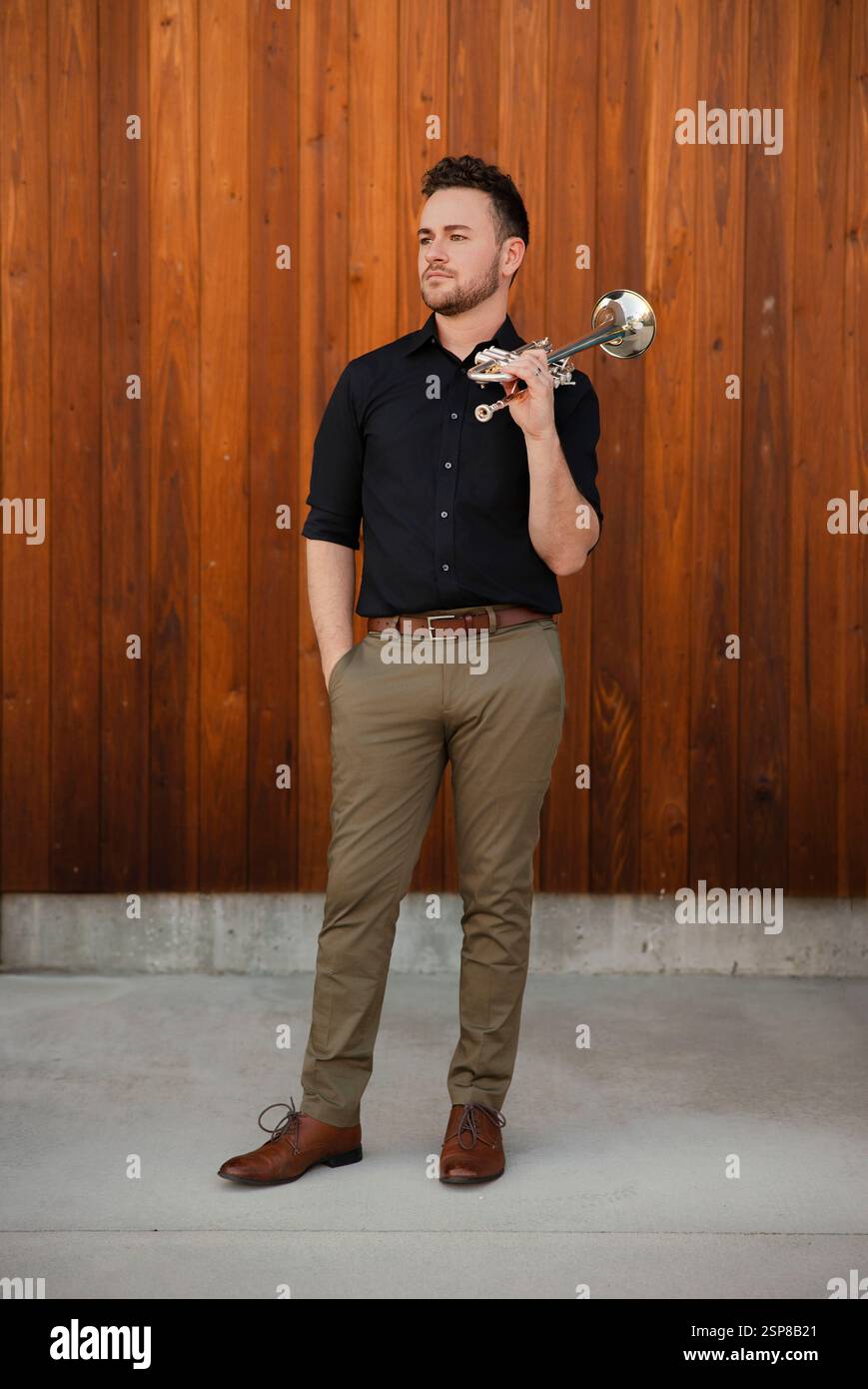 Talented young musician confidently poses outdoors with a trumpet Stock ...